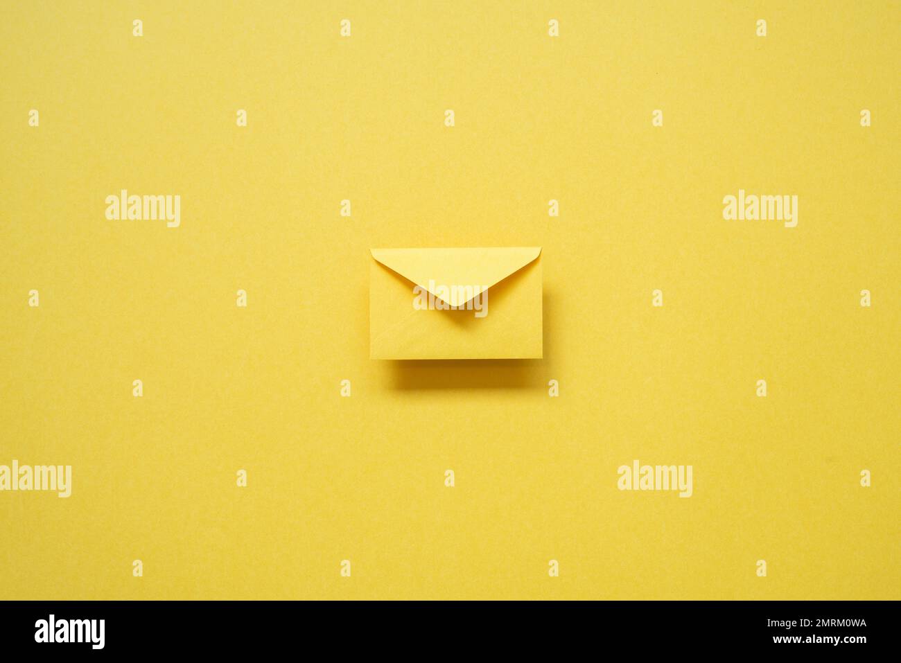 Yellow card envelope on yellow background. top view, copy space ...