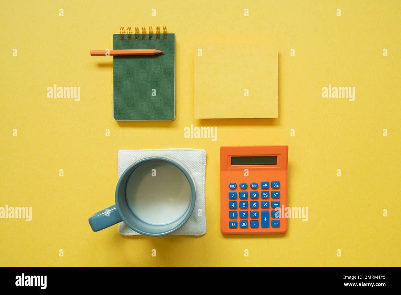 Green notepad, memo paper, color pencil, cup of milk, calculator ...