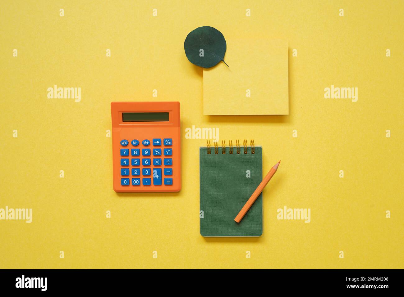 Green notepad, memo paper, color pencil, calculator isolated on yellow ...