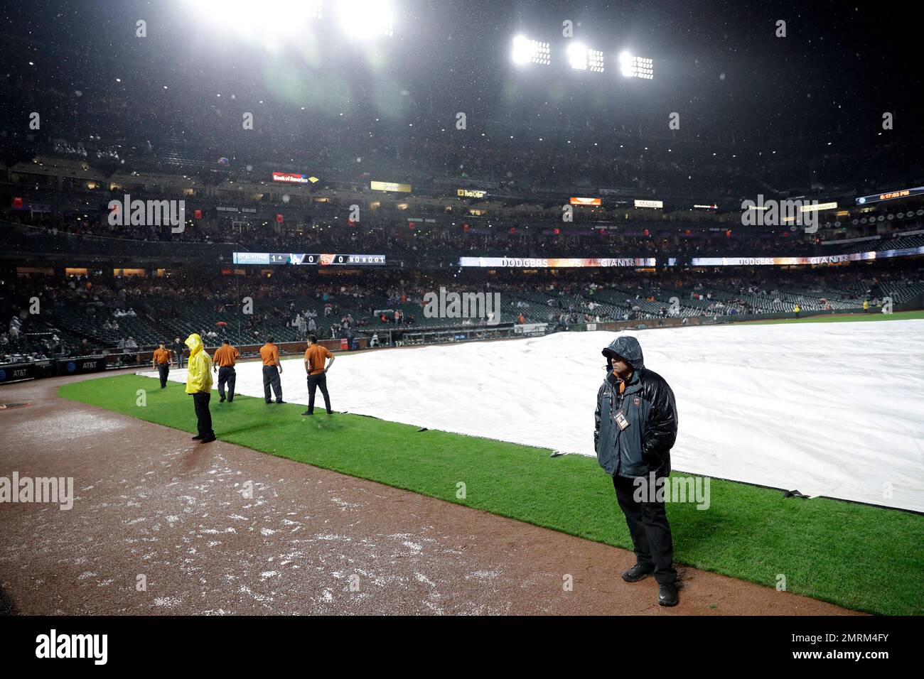 The field is covered with a tarp for a rain delay during a baseball ...