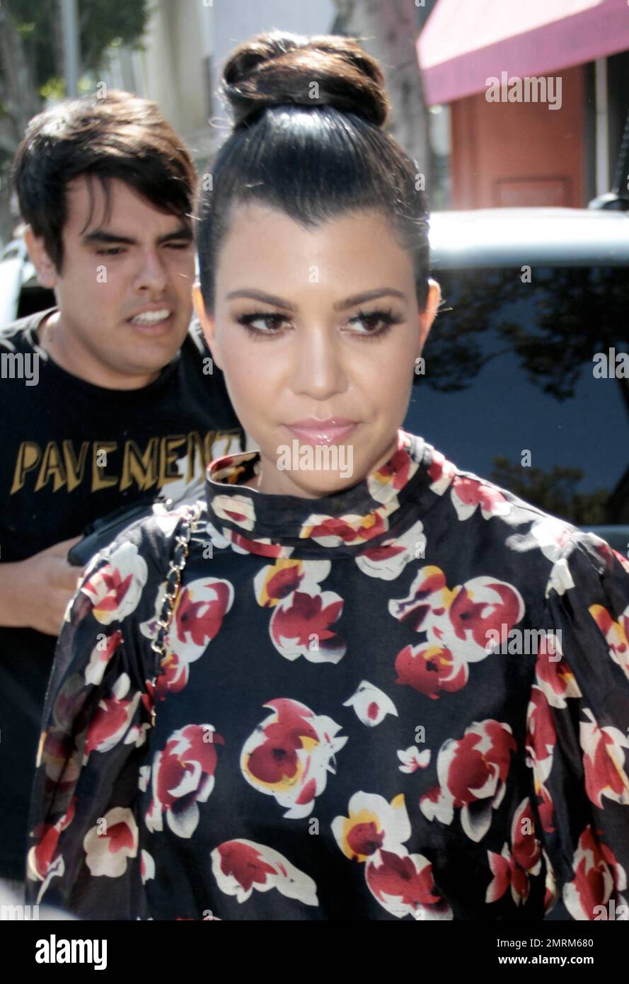 With her hair up in a bun and wearing a floral patterned dress ...