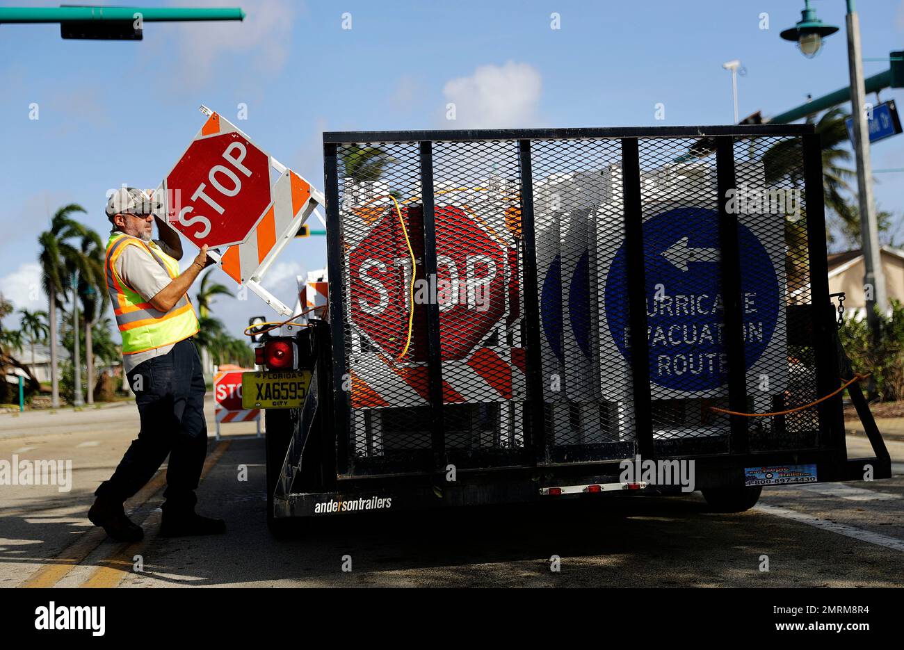 A city worker places stop signs at intersections after Hurricane Irma ...