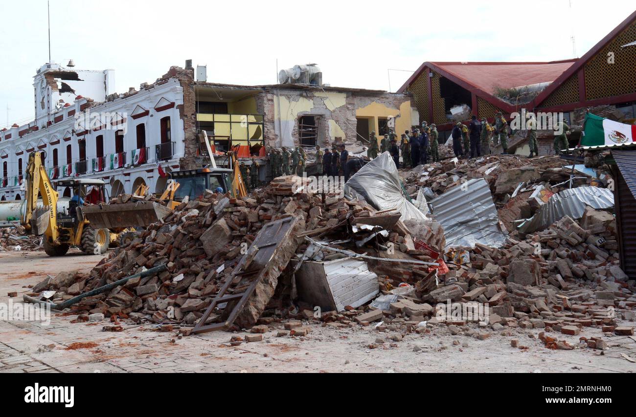 Soldiers remove debris from a partly collapsed municipal building after ...