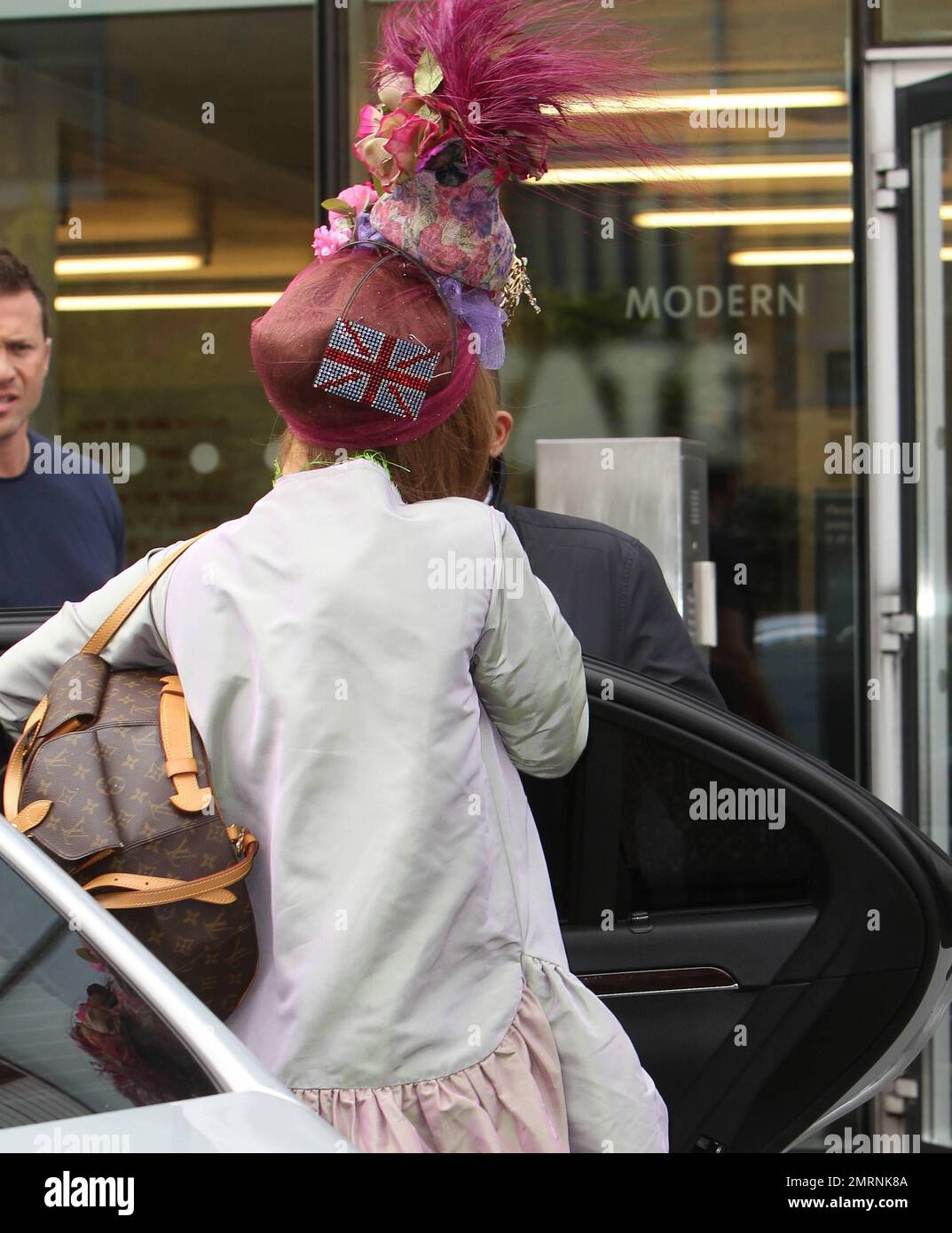 Lady Gaga wears a colorful hat and long white dress as she leaves her ...