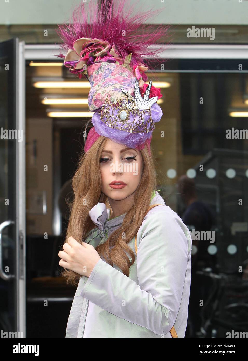 Lady Gaga wears a colorful hat and long white dress as she leaves her ...