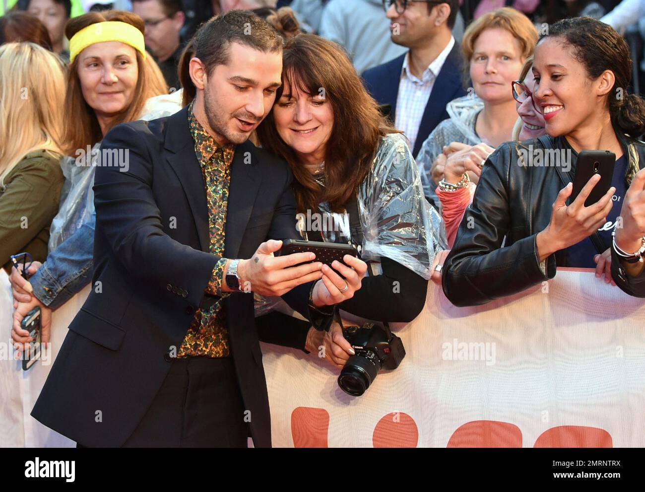 Shia LaBeouf, left, takes a photo with a fan as he attends the opening ...