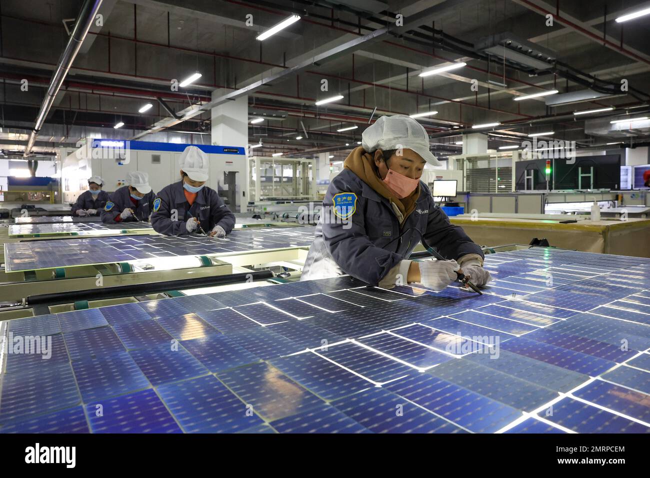 Workers are busy producing the solar photovoltaic modules at the ...