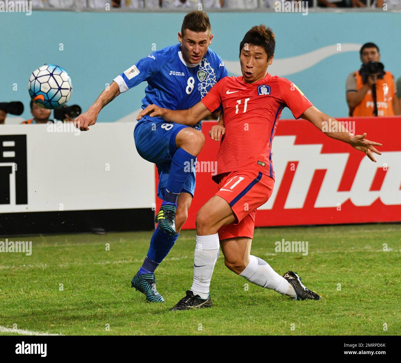 Uzbekistan's Server Djeparov, left, with Korea Republic's Lee Keun ho during the World Cup Group ...