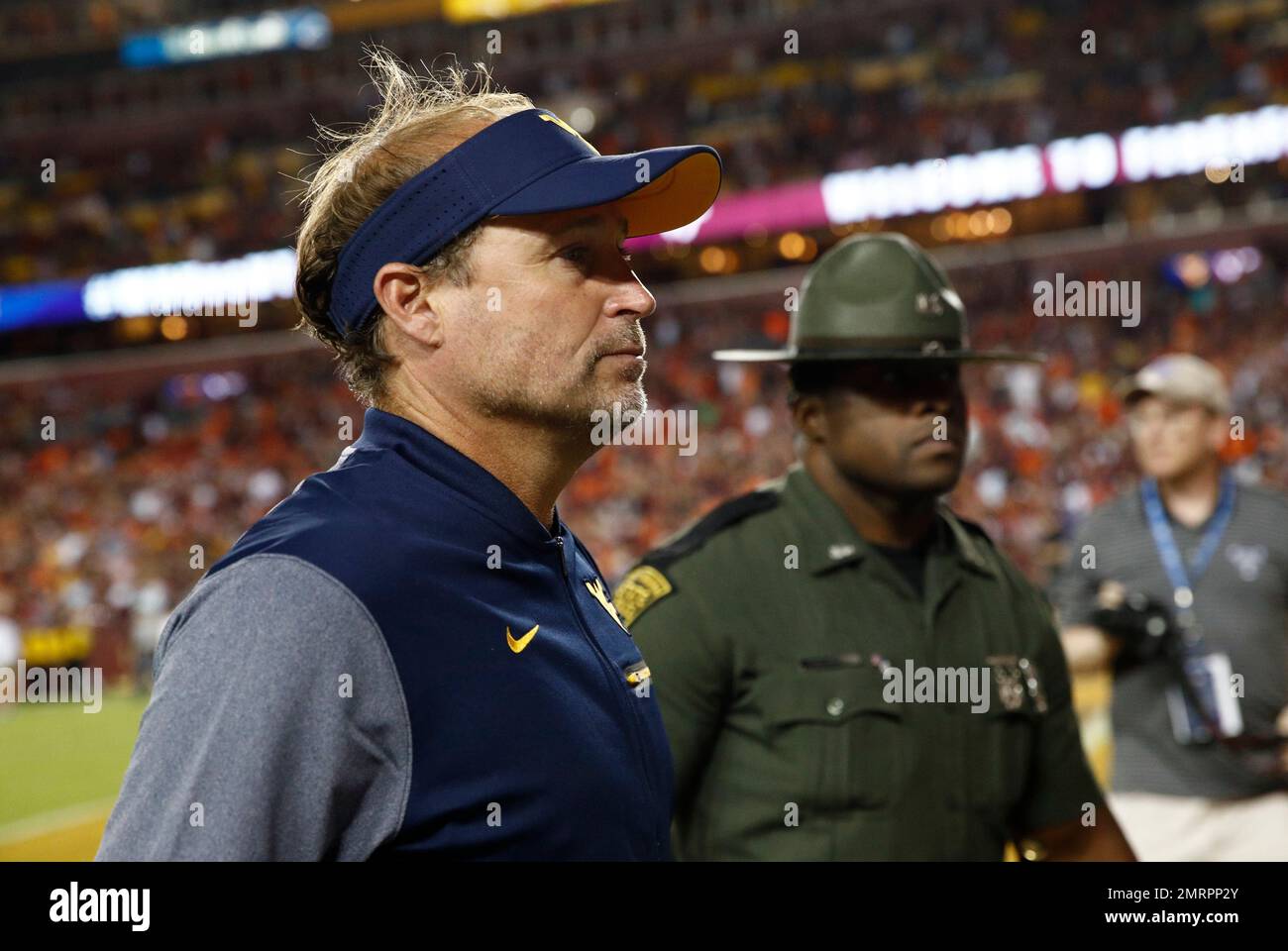 West Virginia head coach Dana Holgorsen walks off the field after an ...