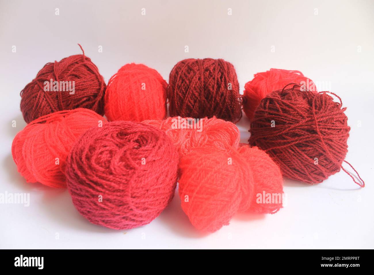 Red series of wool yarn on a white background Stock Photo - Alamy