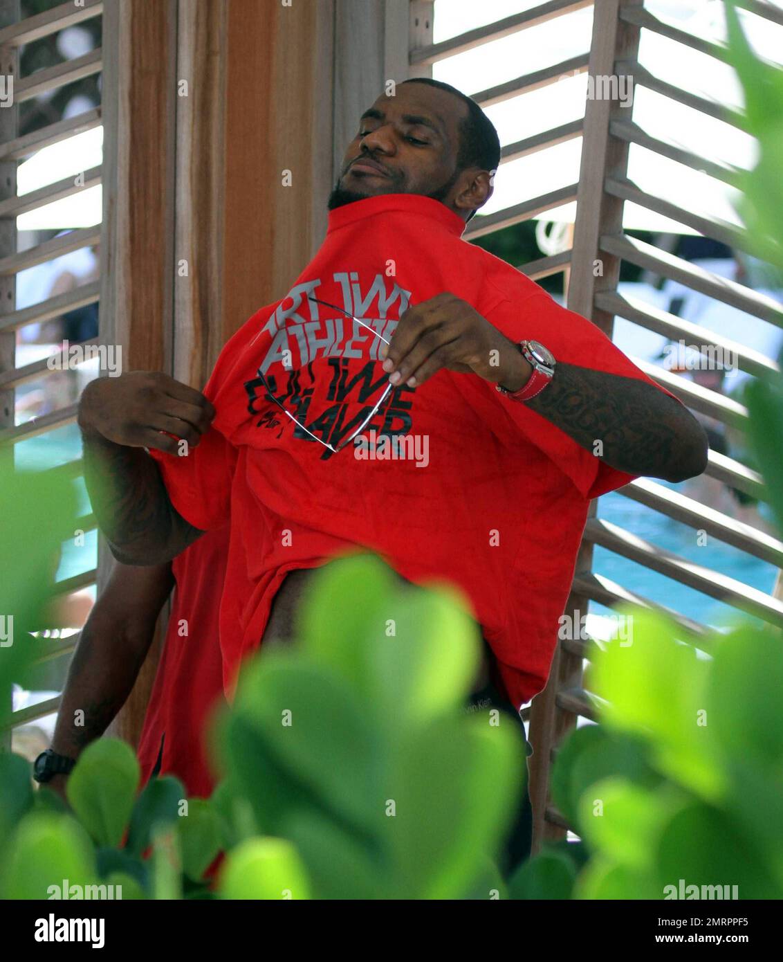 Lebron James pulls his shirt on following a day at the pool. Miami, FL ...