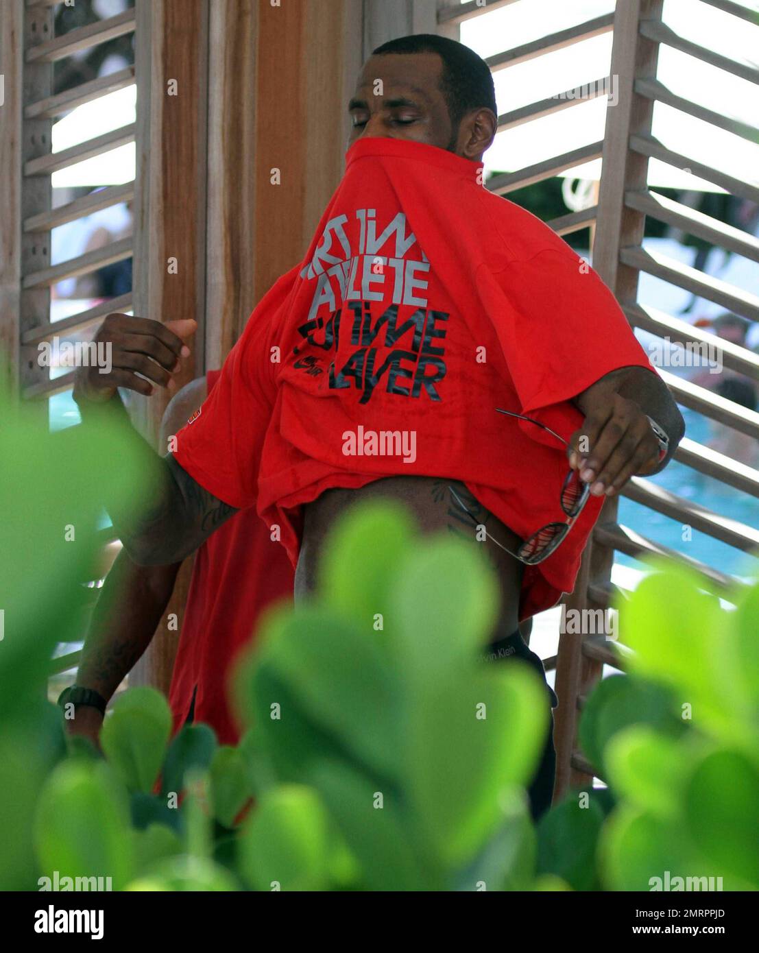Lebron James pulls his shirt on following a day at the pool. Miami, FL ...