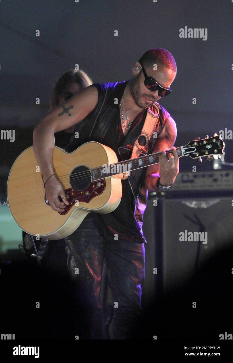 Lenny Kravitz shows off his tattoos in a sleeveless leather vest as he ...