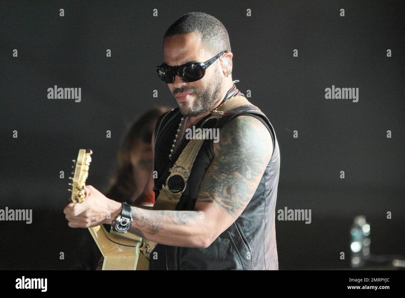 Lenny Kravitz shows off his tattoos in a sleeveless leather vest as he ...