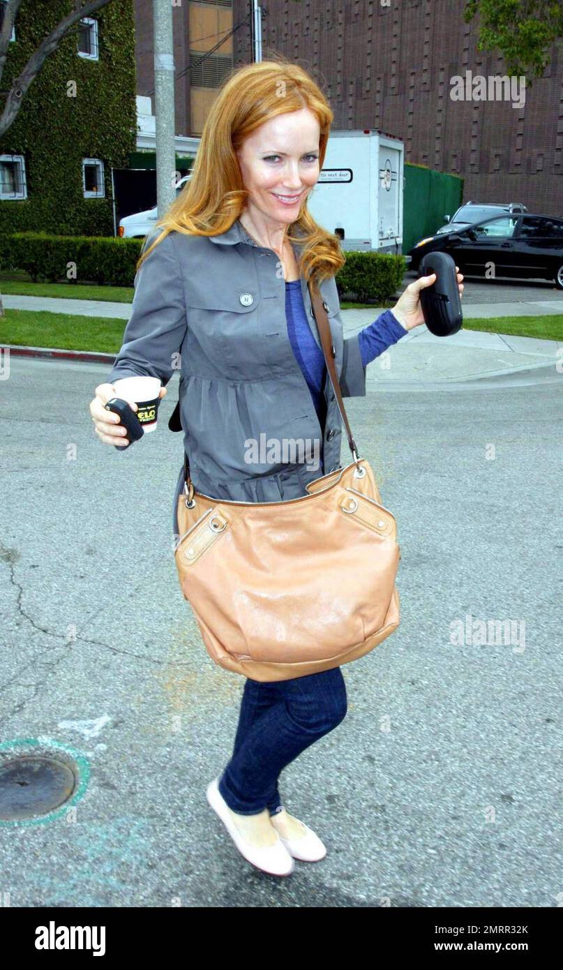 Leslie Mann does her best not to spill her espresso drink as she leaves ...