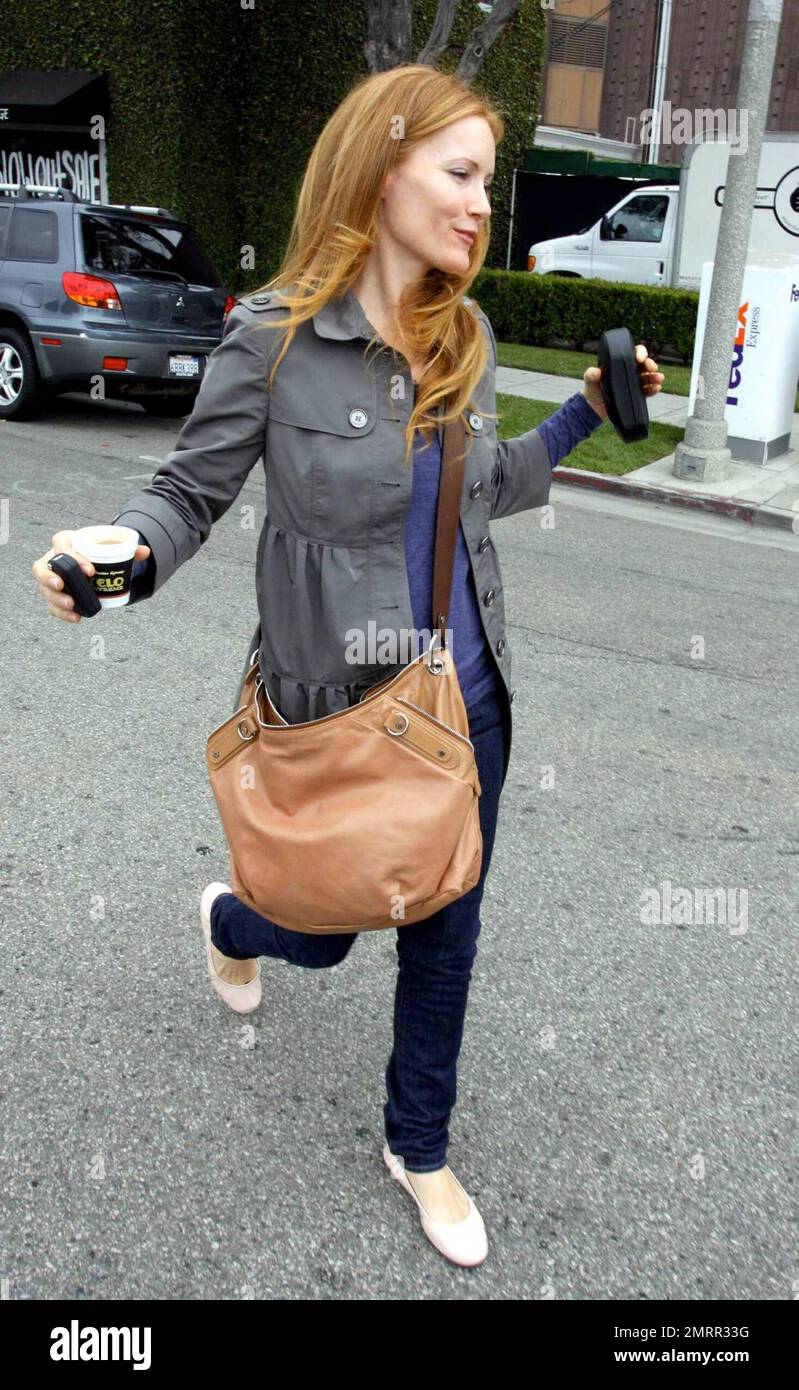 Leslie Mann does her best not to spill her espresso drink as she leaves ...