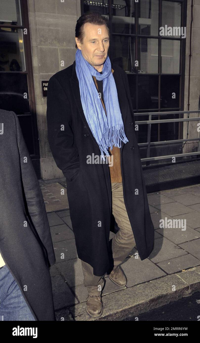 Actor Liam Neeson keeps warm in a black coat and blue scarf as he ...