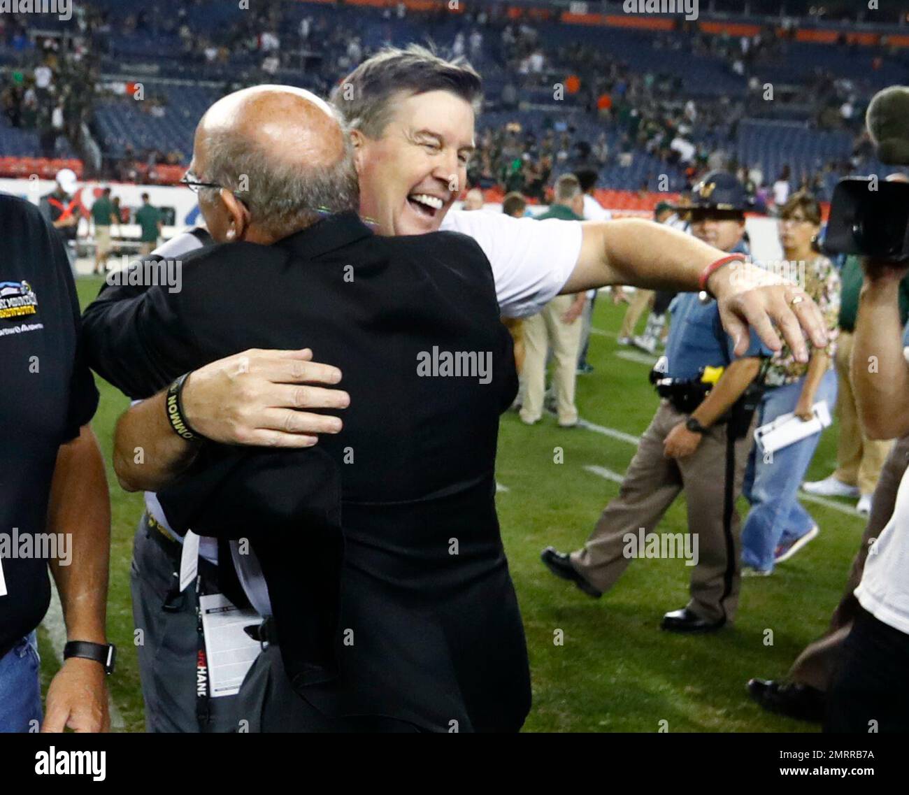 Colorado head coach Mike MacIntyre, back, hugs Phil DeStefano ...