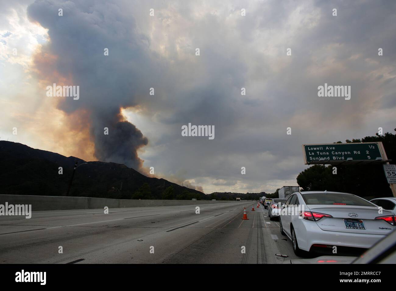 A plume of smoke is seen from the 210 Freeway as a brush fire burns in ...
