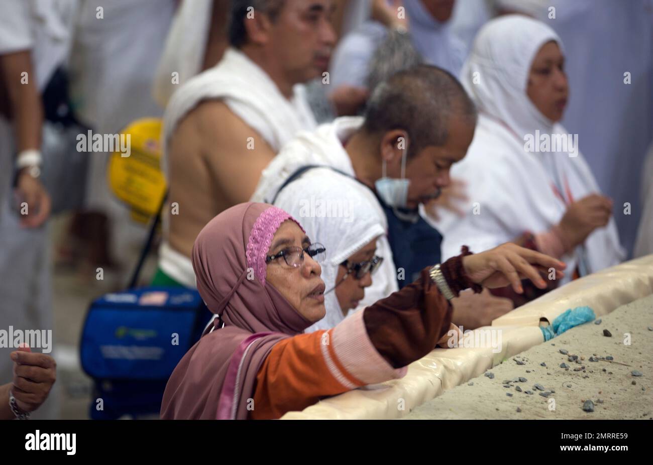 Muslim pilgrims cast stones at the huge stone pillar in the symbolic ...