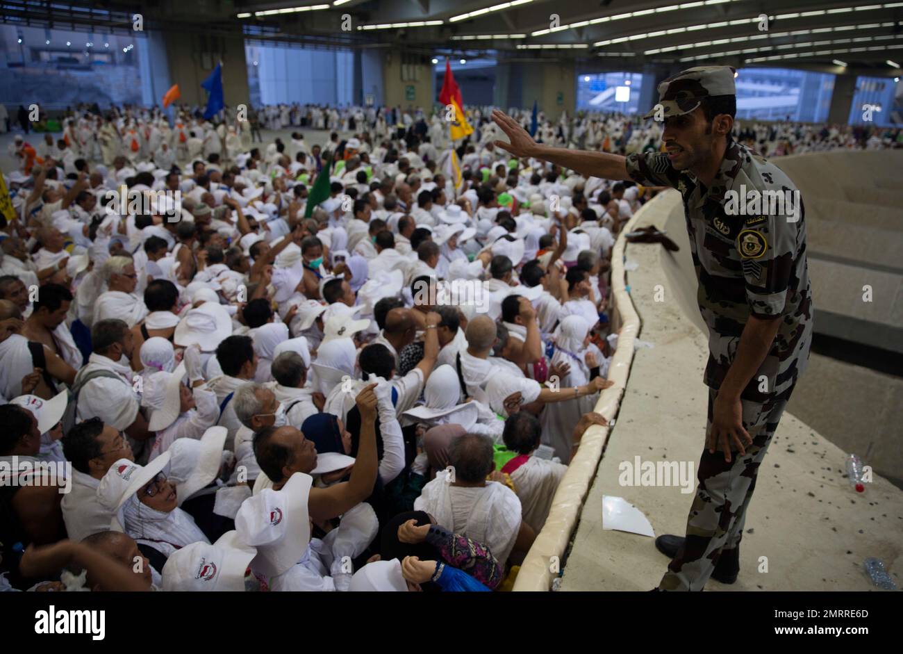 A Saudi security officer controls traffic of Muslim pilgrims cast ...