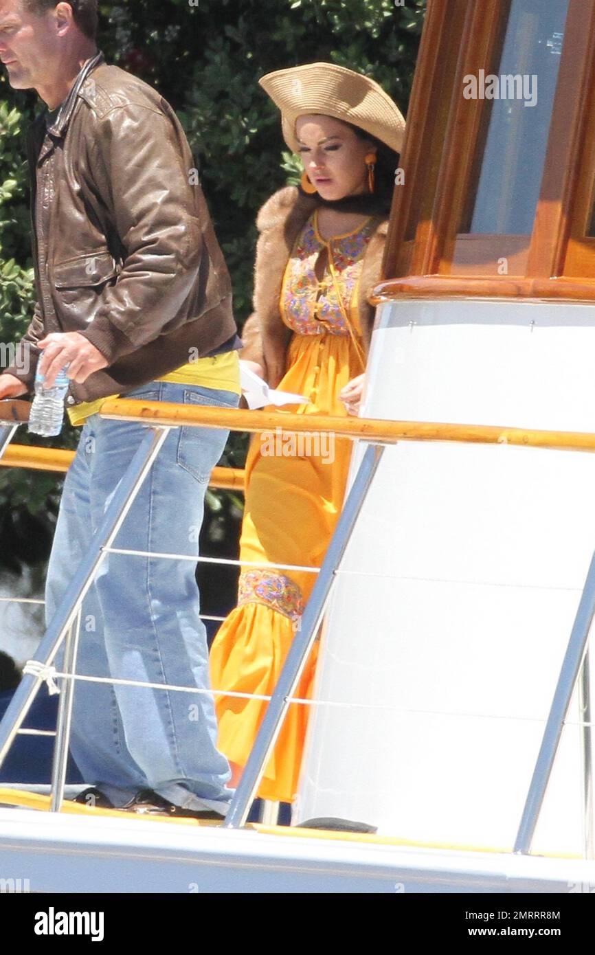 Smoking a cigarette, Lindsay Lohan portrays Elizabeth Taylor, wearing a ...