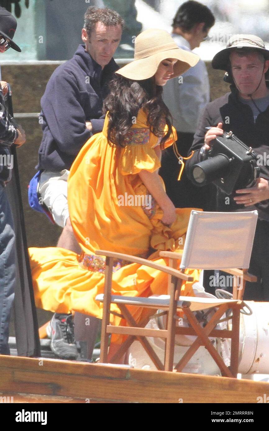 Smoking a cigarette, Lindsay Lohan portrays Elizabeth Taylor, wearing a ...