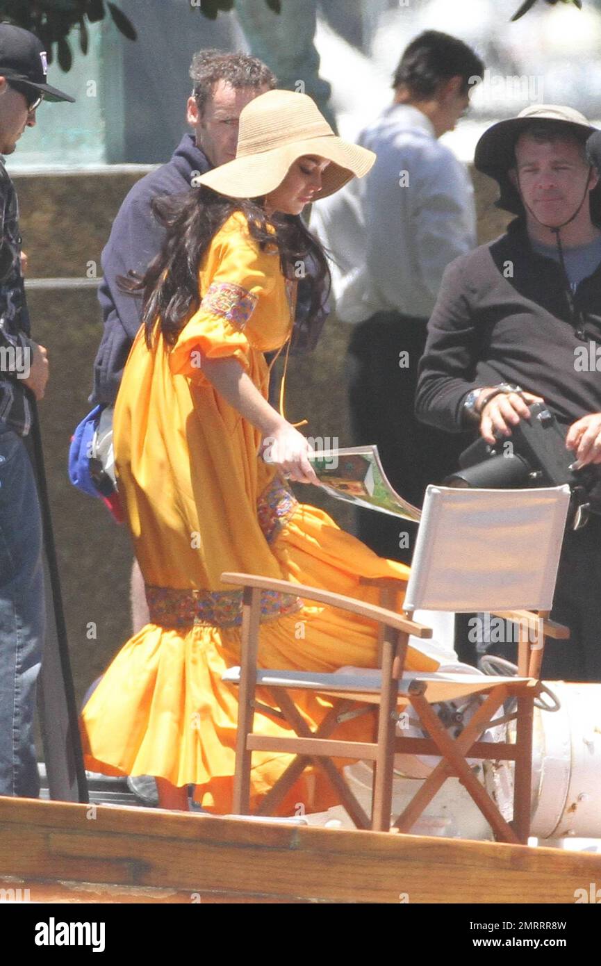 Smoking a cigarette, Lindsay Lohan portrays Elizabeth Taylor, wearing a ...