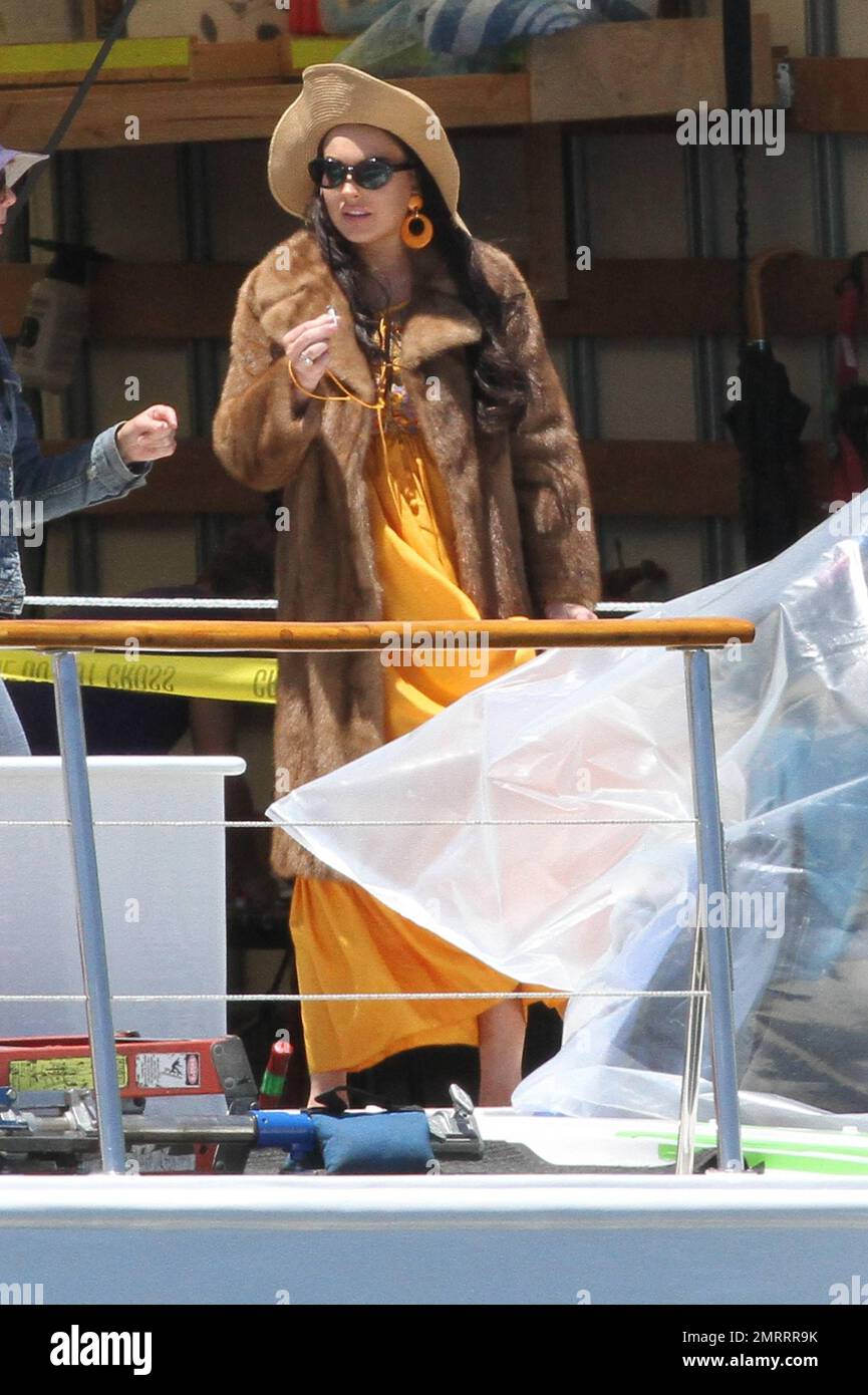 Smoking a cigarette, Lindsay Lohan portrays Elizabeth Taylor, wearing a ...