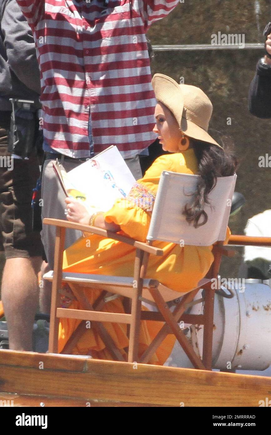 Smoking a cigarette, Lindsay Lohan portrays Elizabeth Taylor, wearing a ...