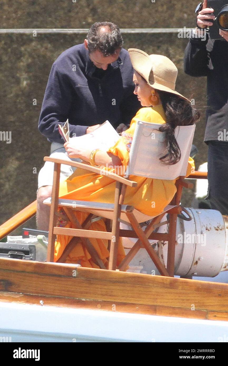 Smoking a cigarette, Lindsay Lohan portrays Elizabeth Taylor, wearing a ...