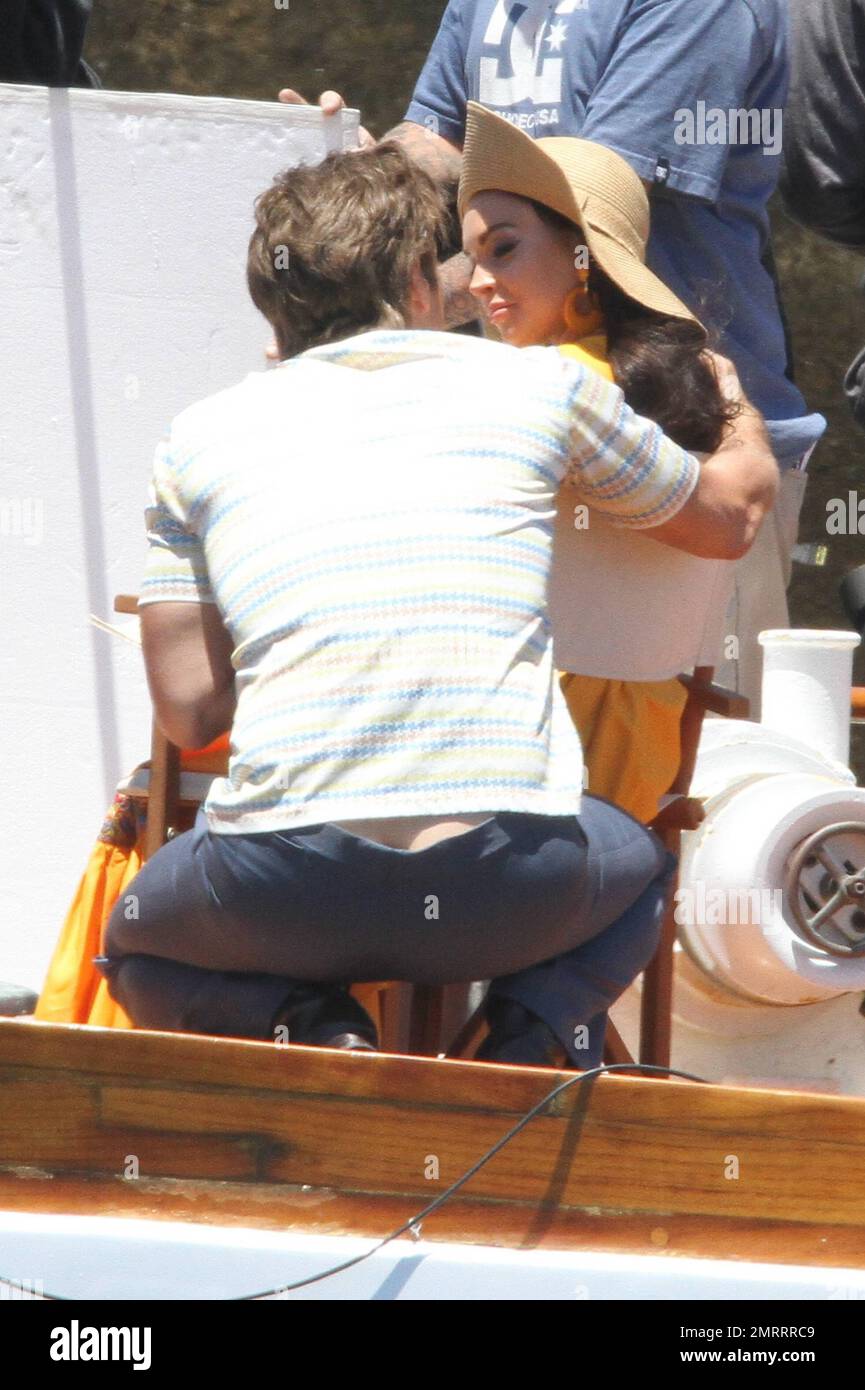 Smoking a cigarette, Lindsay Lohan portrays Elizabeth Taylor, wearing a ...