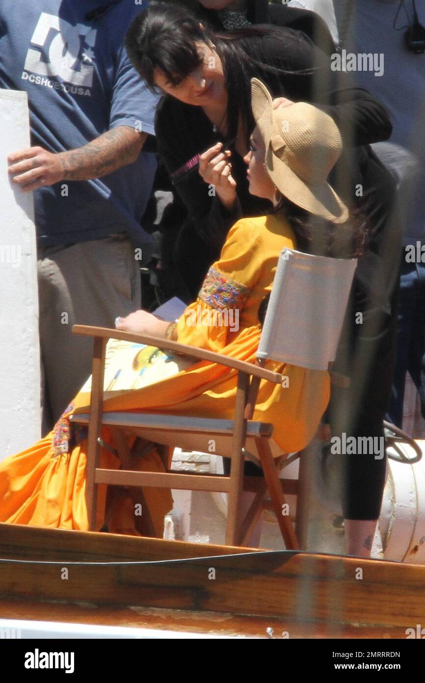 Smoking a cigarette, Lindsay Lohan portrays Elizabeth Taylor, wearing a ...