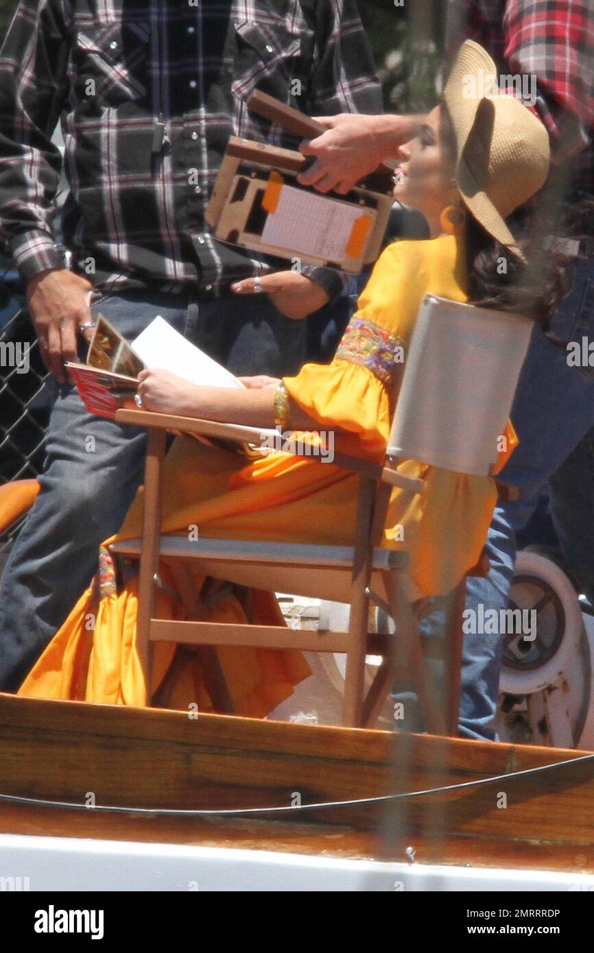 Smoking a cigarette, Lindsay Lohan portrays Elizabeth Taylor, wearing a ...