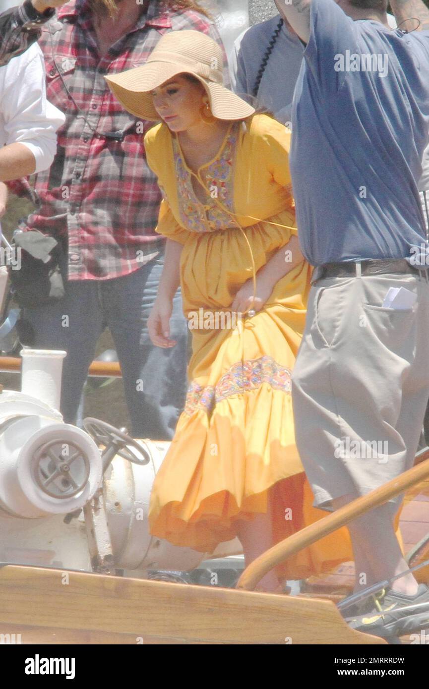 Smoking a cigarette, Lindsay Lohan portrays Elizabeth Taylor, wearing a ...