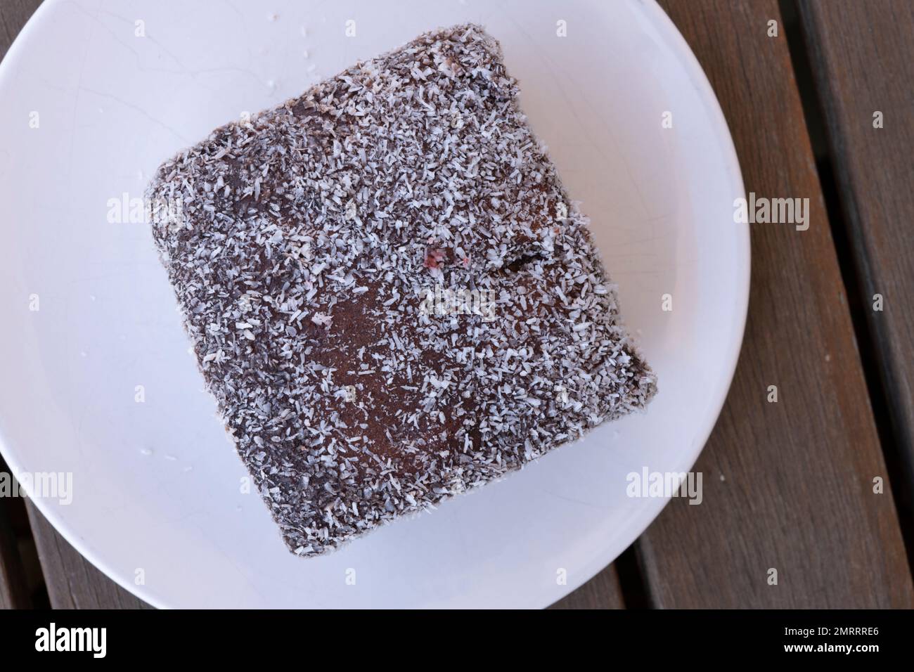 A traditional chocolate lamington on a plate in a bakery in South ...