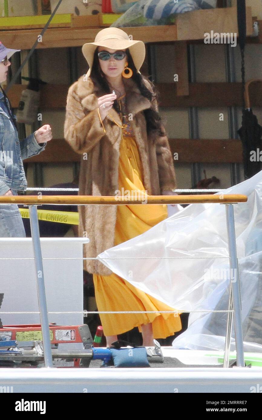 Smoking a cigarette, Lindsay Lohan portrays Elizabeth Taylor, wearing a ...