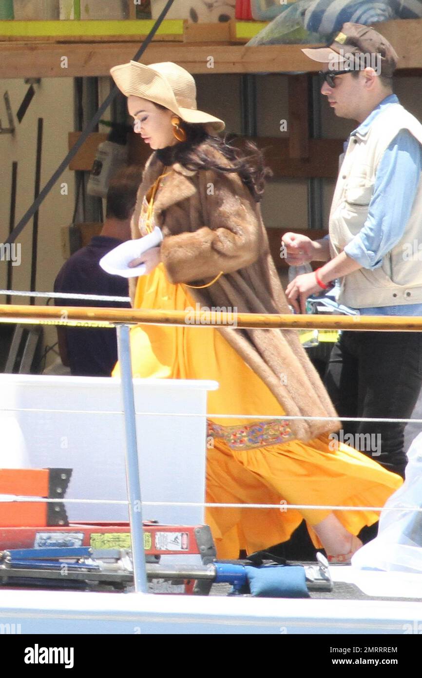 Smoking a cigarette, Lindsay Lohan portrays Elizabeth Taylor, wearing a ...