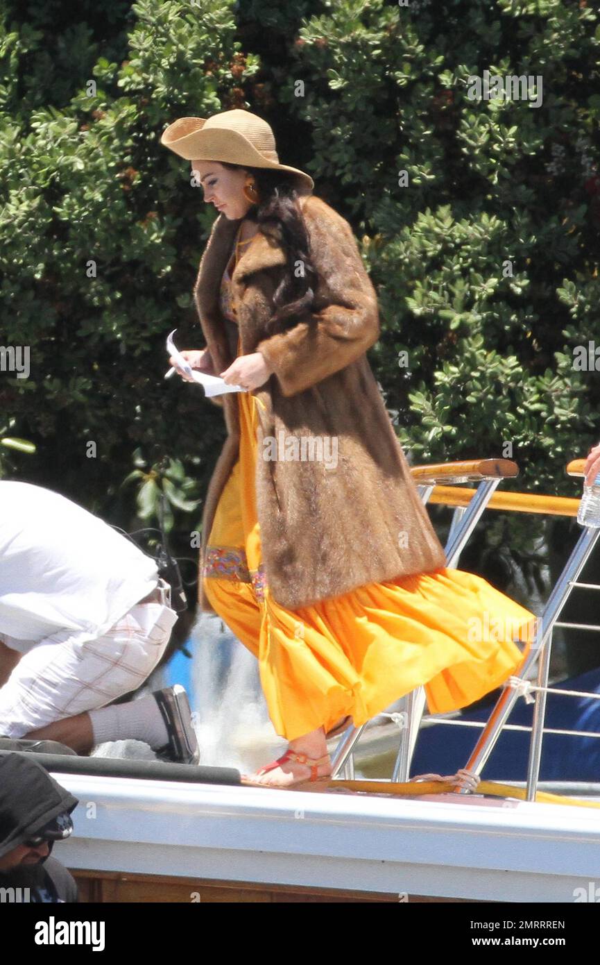 Smoking a cigarette, Lindsay Lohan portrays Elizabeth Taylor, wearing a ...