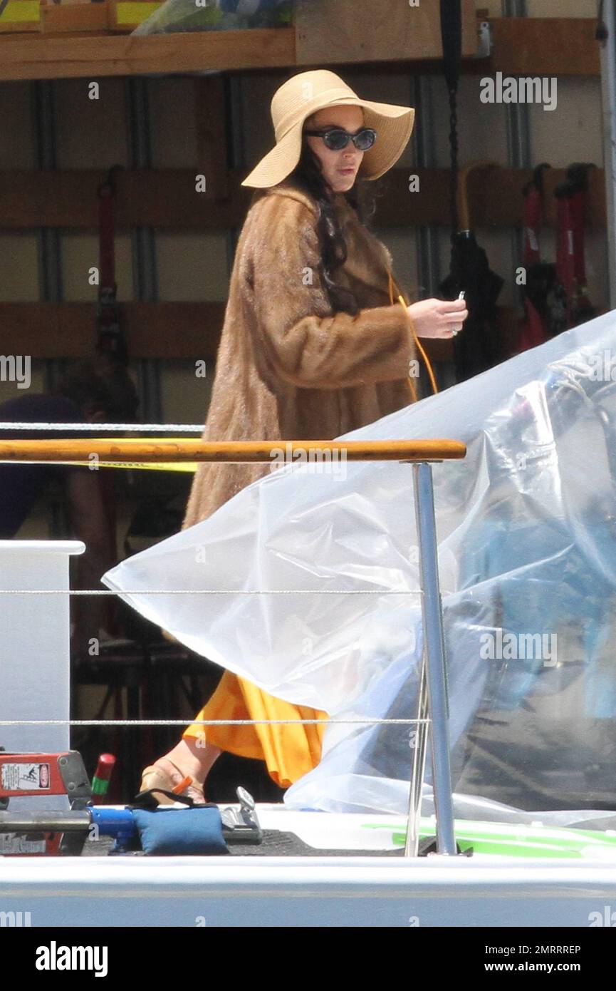 Smoking a cigarette, Lindsay Lohan portrays Elizabeth Taylor, wearing a ...