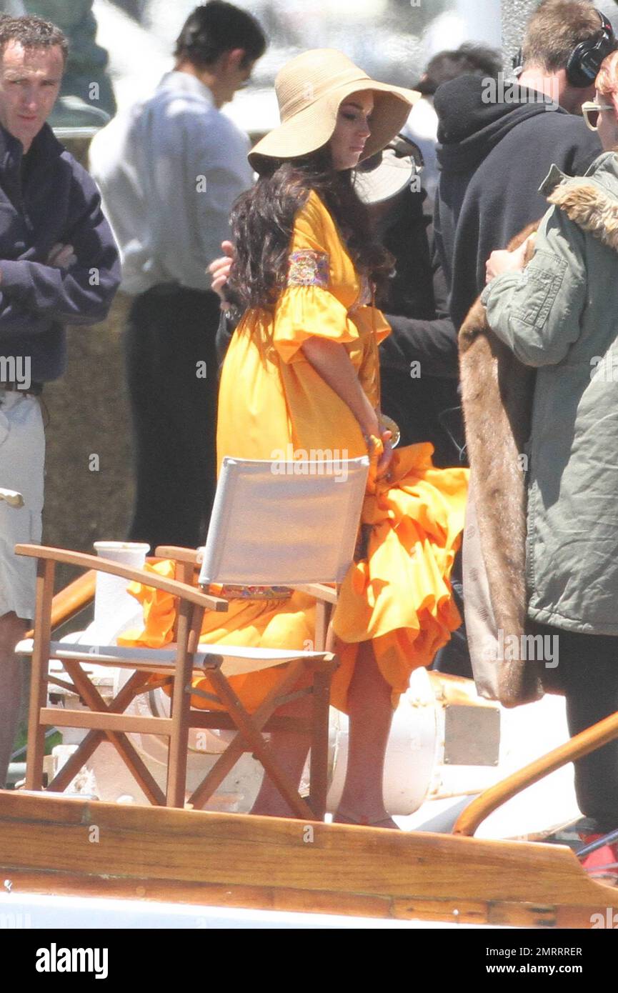 Smoking a cigarette, Lindsay Lohan portrays Elizabeth Taylor, wearing a ...