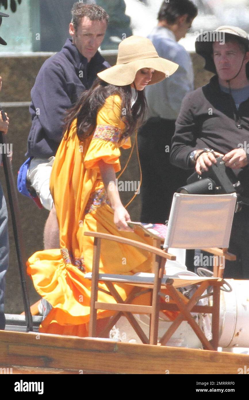 Smoking a cigarette, Lindsay Lohan portrays Elizabeth Taylor, wearing a ...