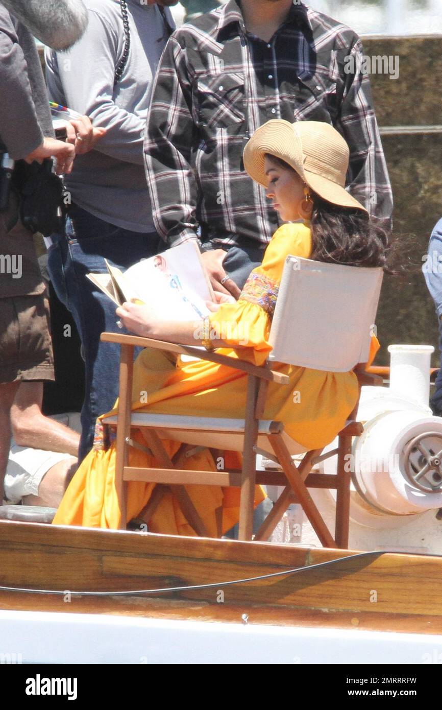 Smoking a cigarette, Lindsay Lohan portrays Elizabeth Taylor, wearing a ...