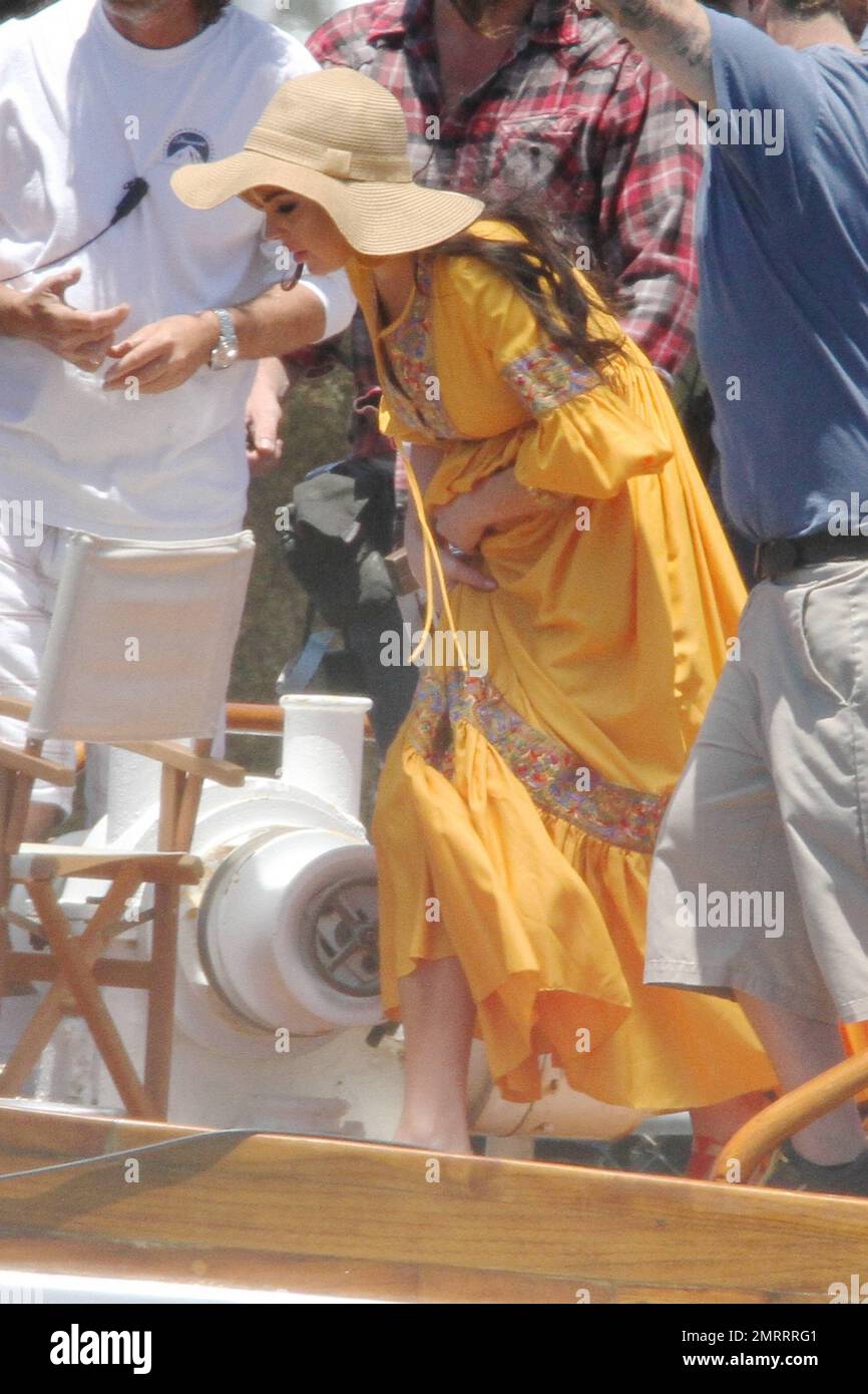 Smoking a cigarette, Lindsay Lohan portrays Elizabeth Taylor, wearing a ...