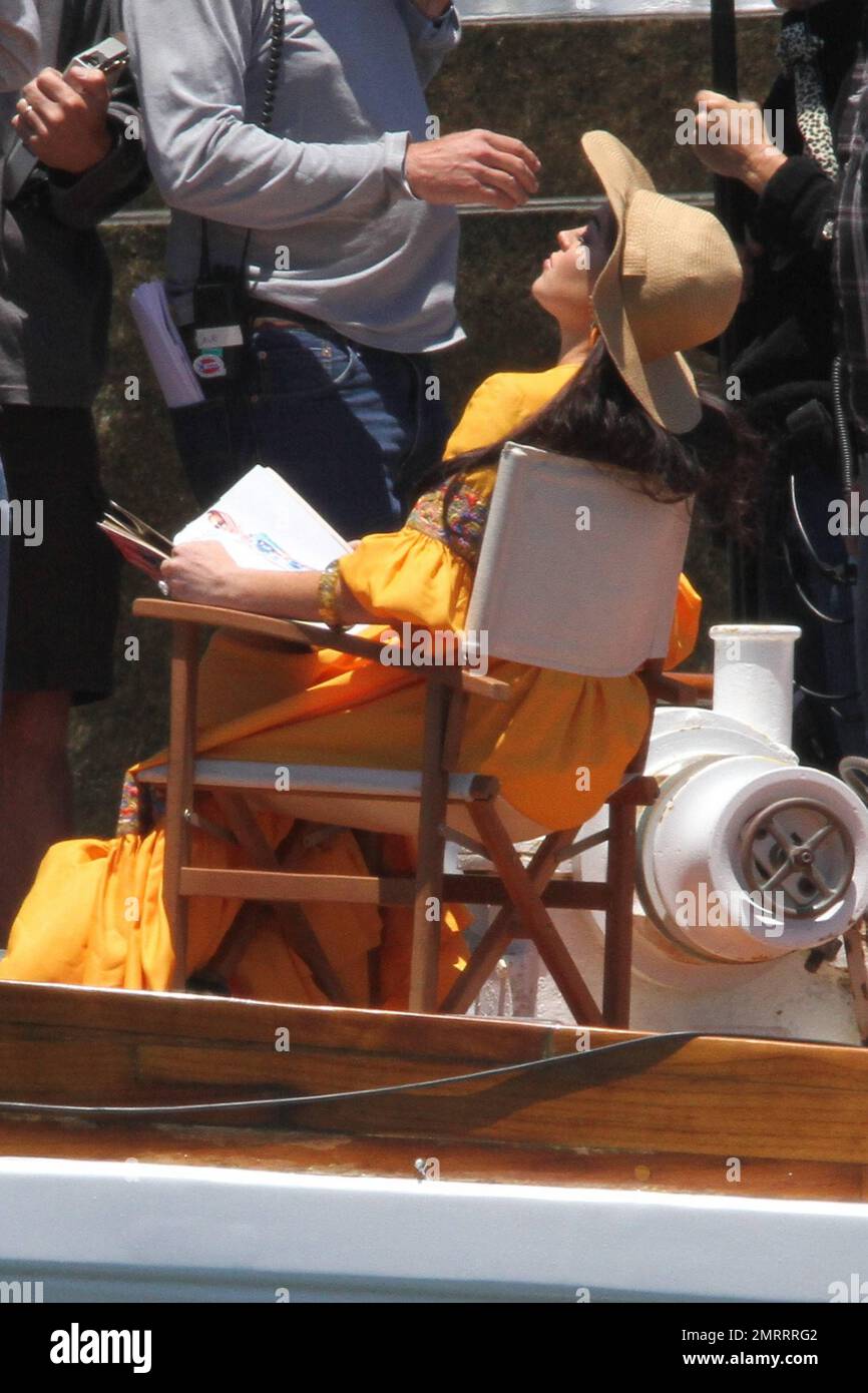 Smoking a cigarette, Lindsay Lohan portrays Elizabeth Taylor, wearing a ...