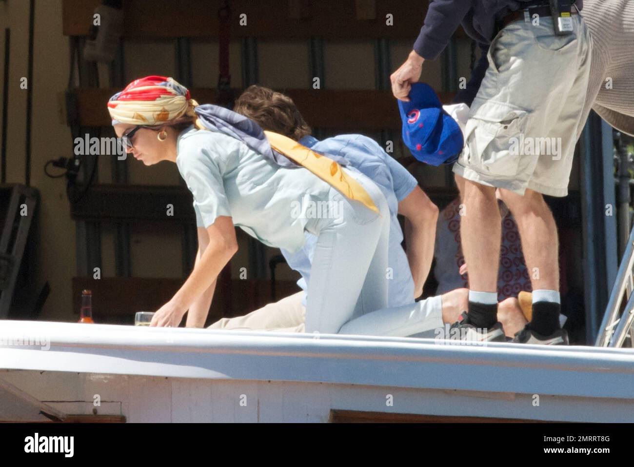 Wearing a patterned wrap on her head paired with a light green top and white jeans, actress ...