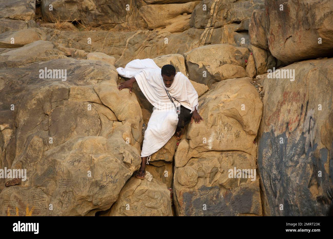 A pilgrim climbs Jabal Al Rahma holy mountain, or the mountain of ...