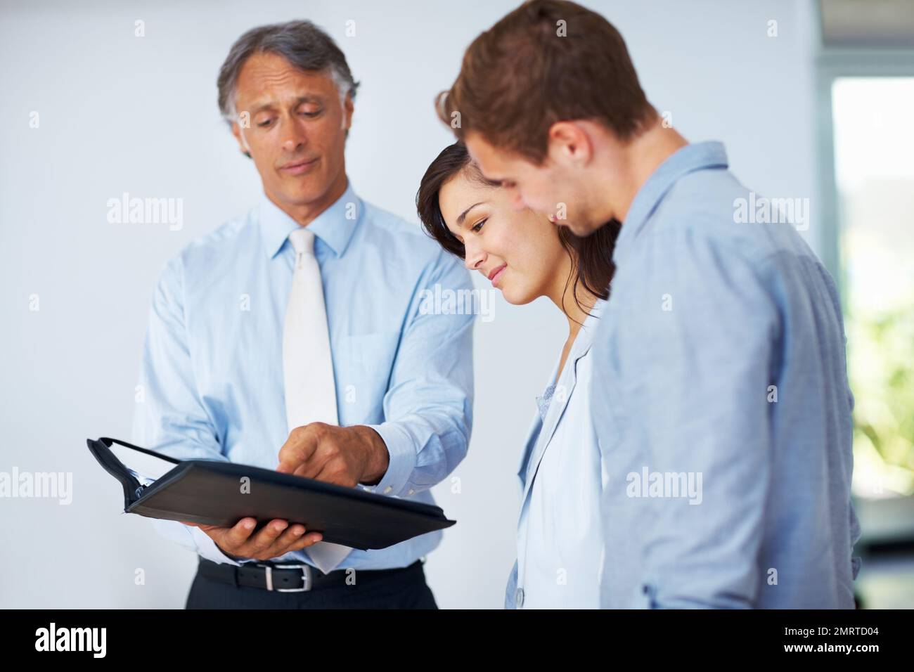 Business man explaining documents to colleagues. Portrait of mature ...
