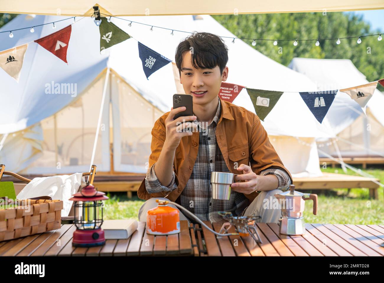 The boy sit under the awning see a mobile phone Stock Photo - Alamy
