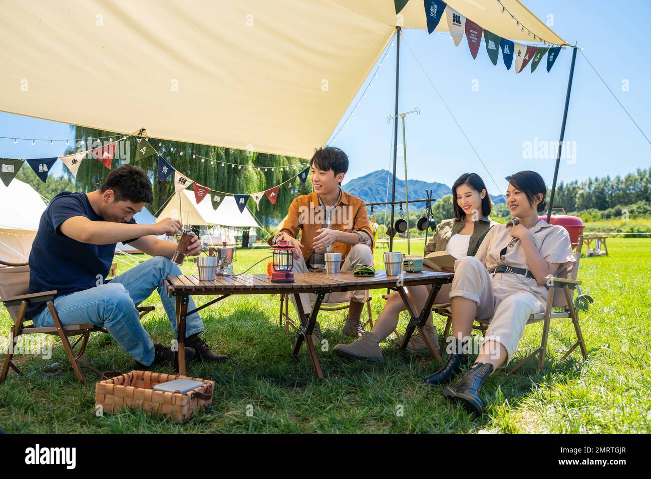A group of people sat under the awning to drink coffee Stock Photo - Alamy
